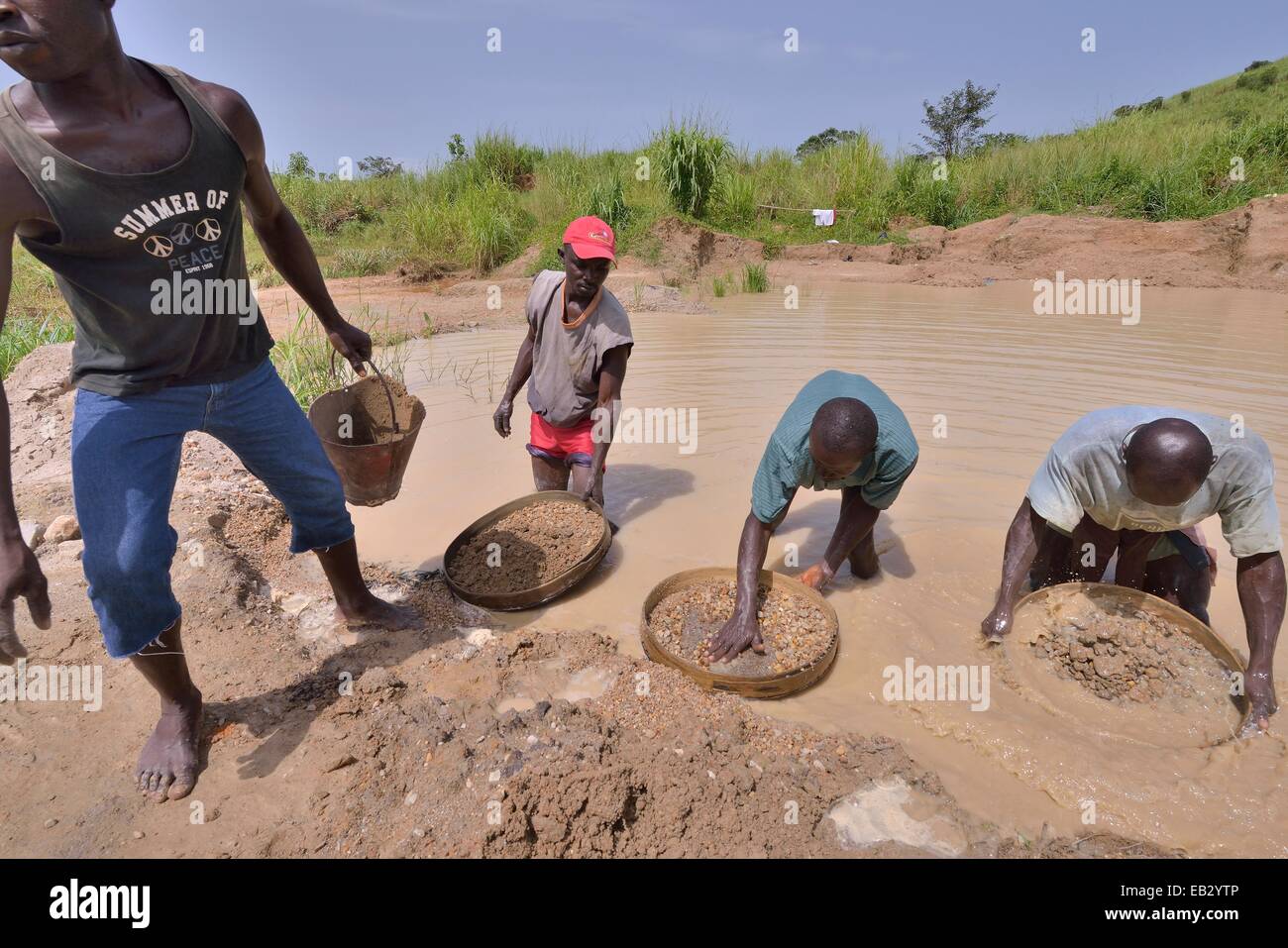 Diamond hunters searching for diamonds in a mine with sieves, near ...