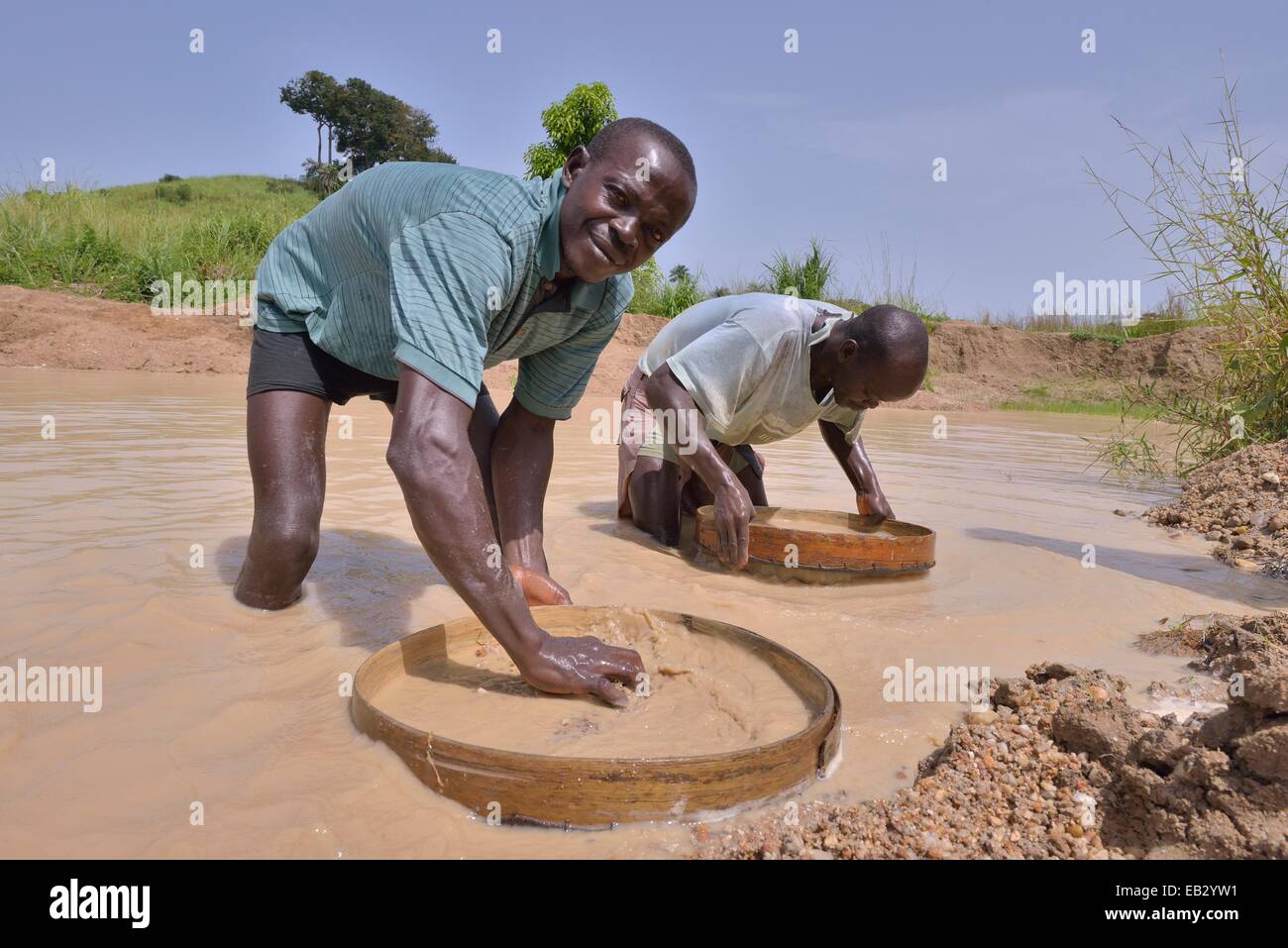 Diamond hunters searching for diamonds in a mine with sieves, near ...