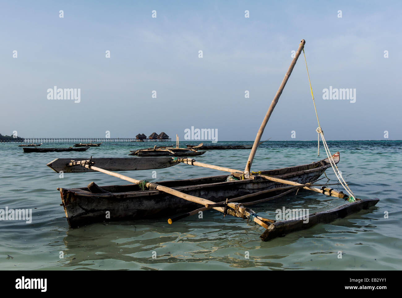 A small wooden fishing dhow moored in the shallows of a tropical island ...