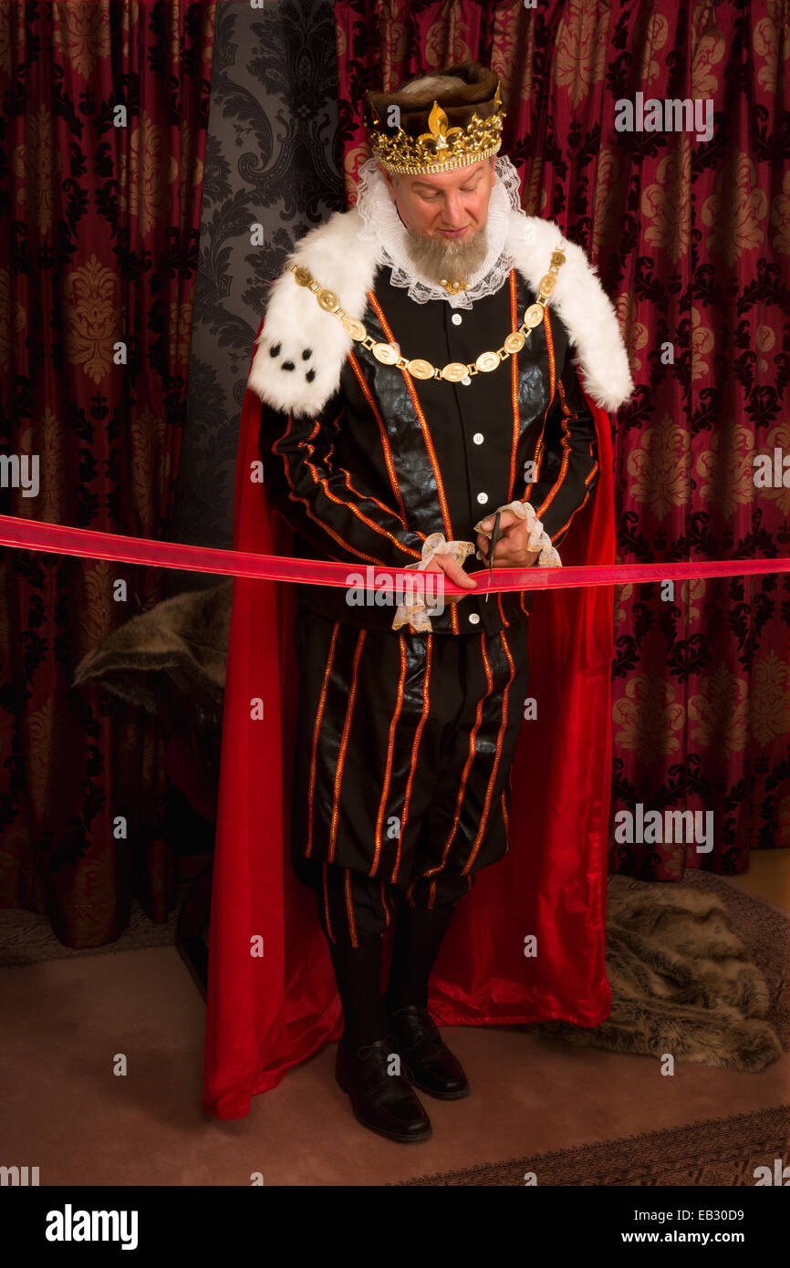 Royal king cutting a red ribbon with scissors Stock Photo - Alamy