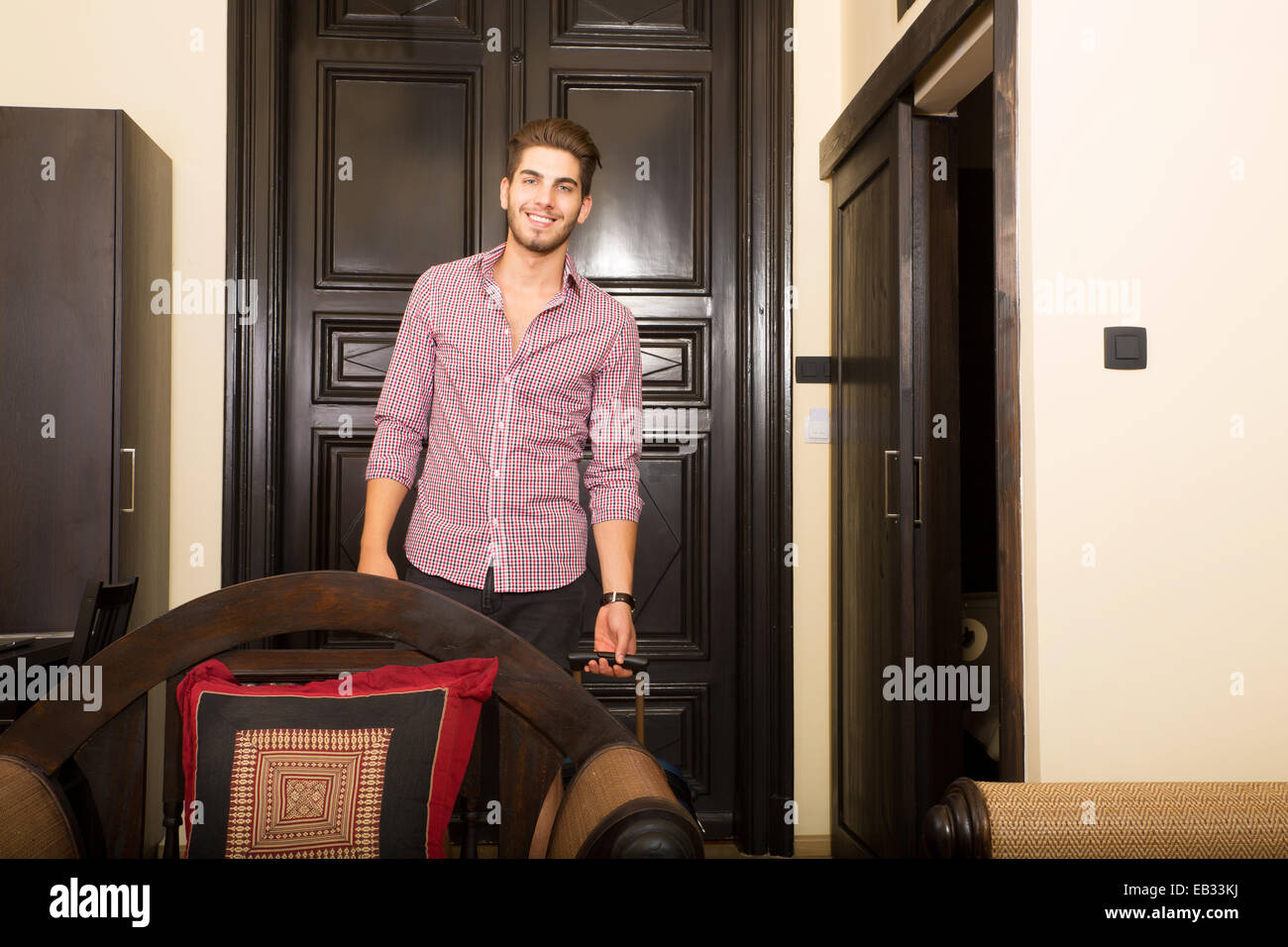 A young and happy man arriving to a hotel room Stock Photo - Alamy