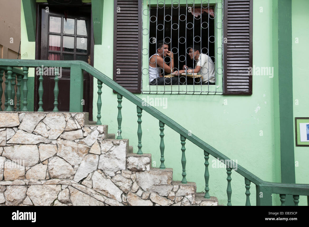 Two young men sit in a cafe window in the colorful Las Penas ...