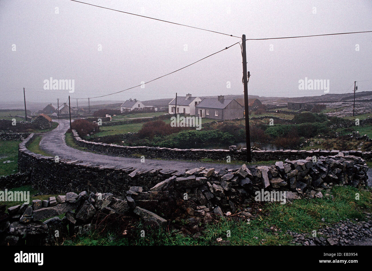 Winding misty wet country road with cottages on Inishmore, Aran Islands ...