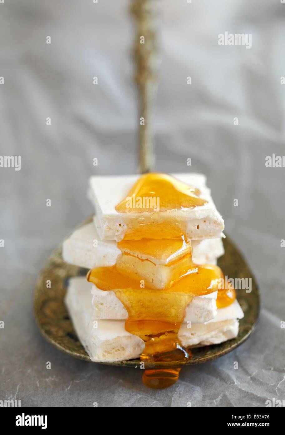 Square pieces of white, plain nougat in stack on metal spoon covered in ...