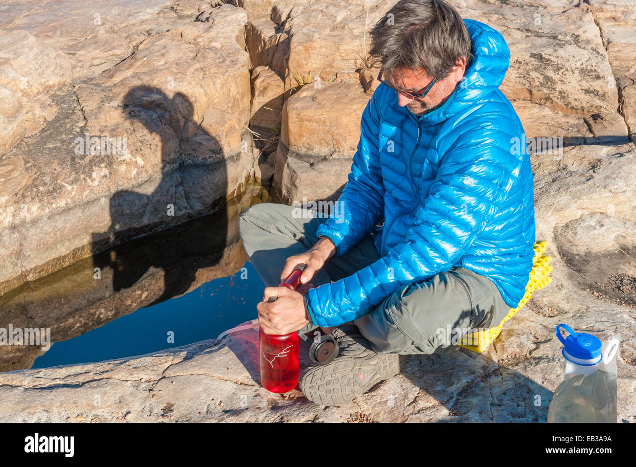 Man filtering water from a rock pool, Arizona, United States Stock ...