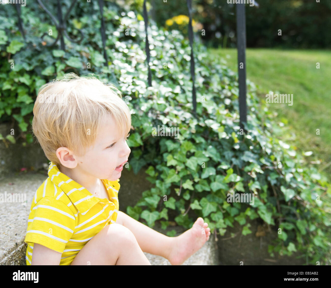 Boy sitting on steps Stock Photo - Alamy
