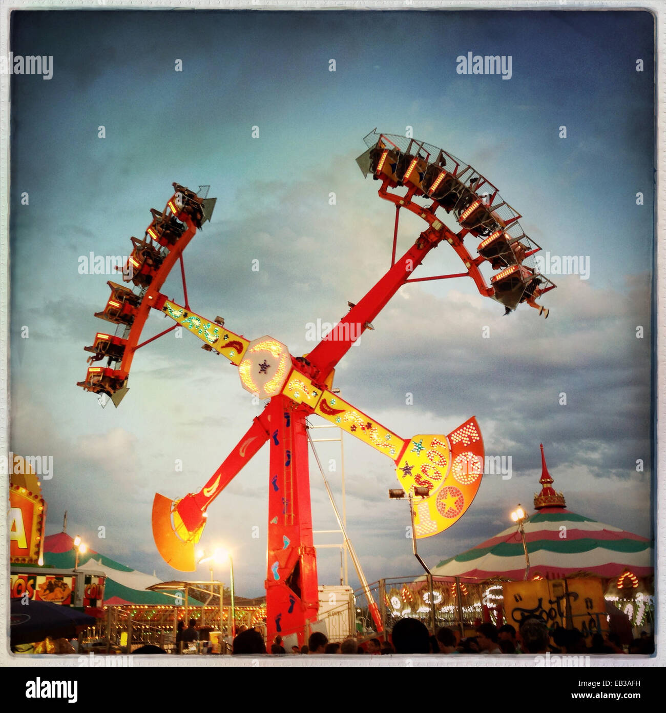 Illuminated amusement park ride under cloudy sky Stock Photo - Alamy