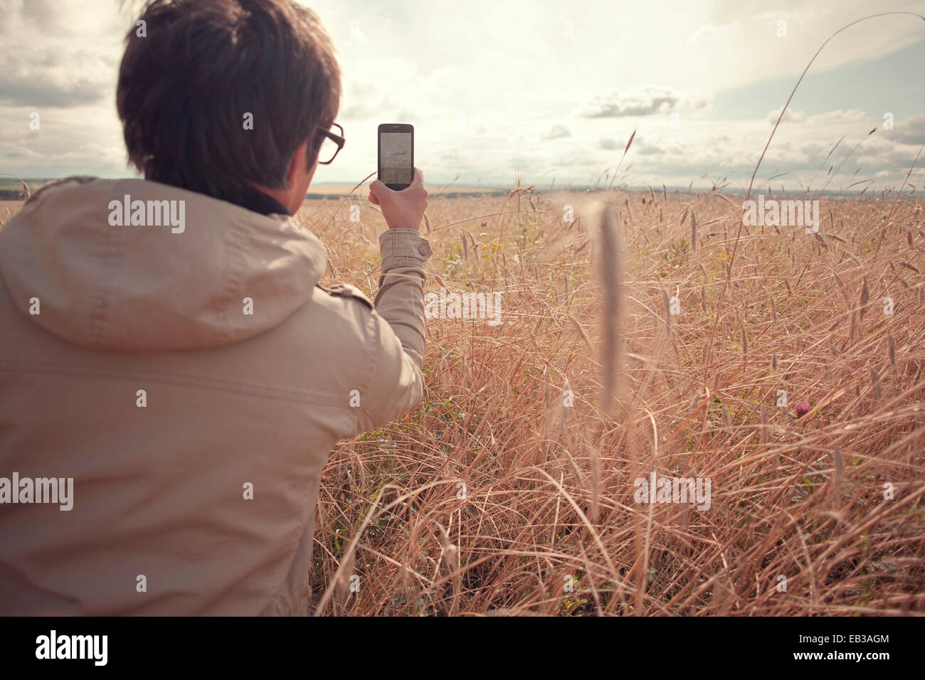 Mari man photographing rural field with cell phone Stock Photo - Alamy
