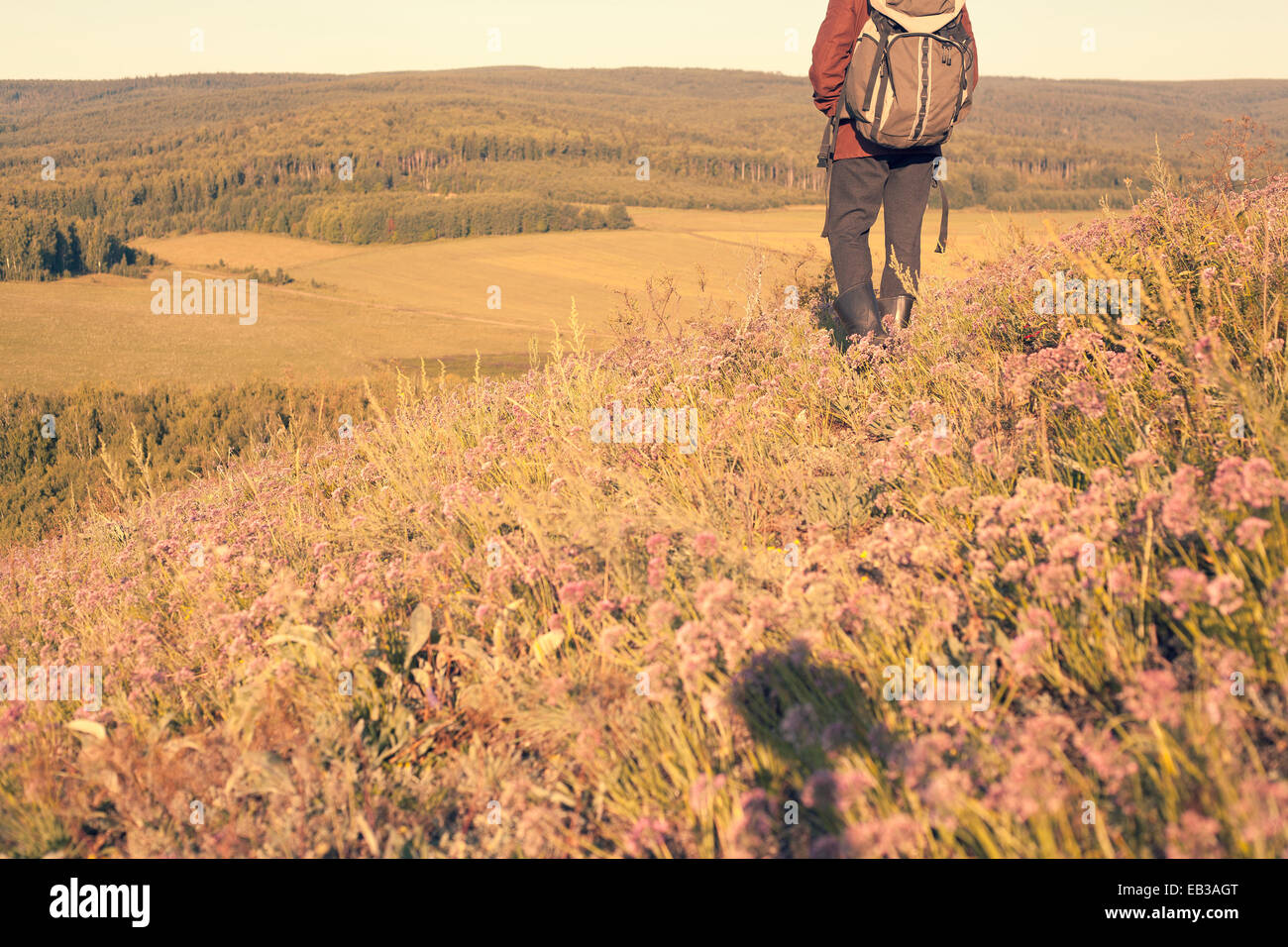 Mari man carrying backpack in rural field Stock Photo - Alamy