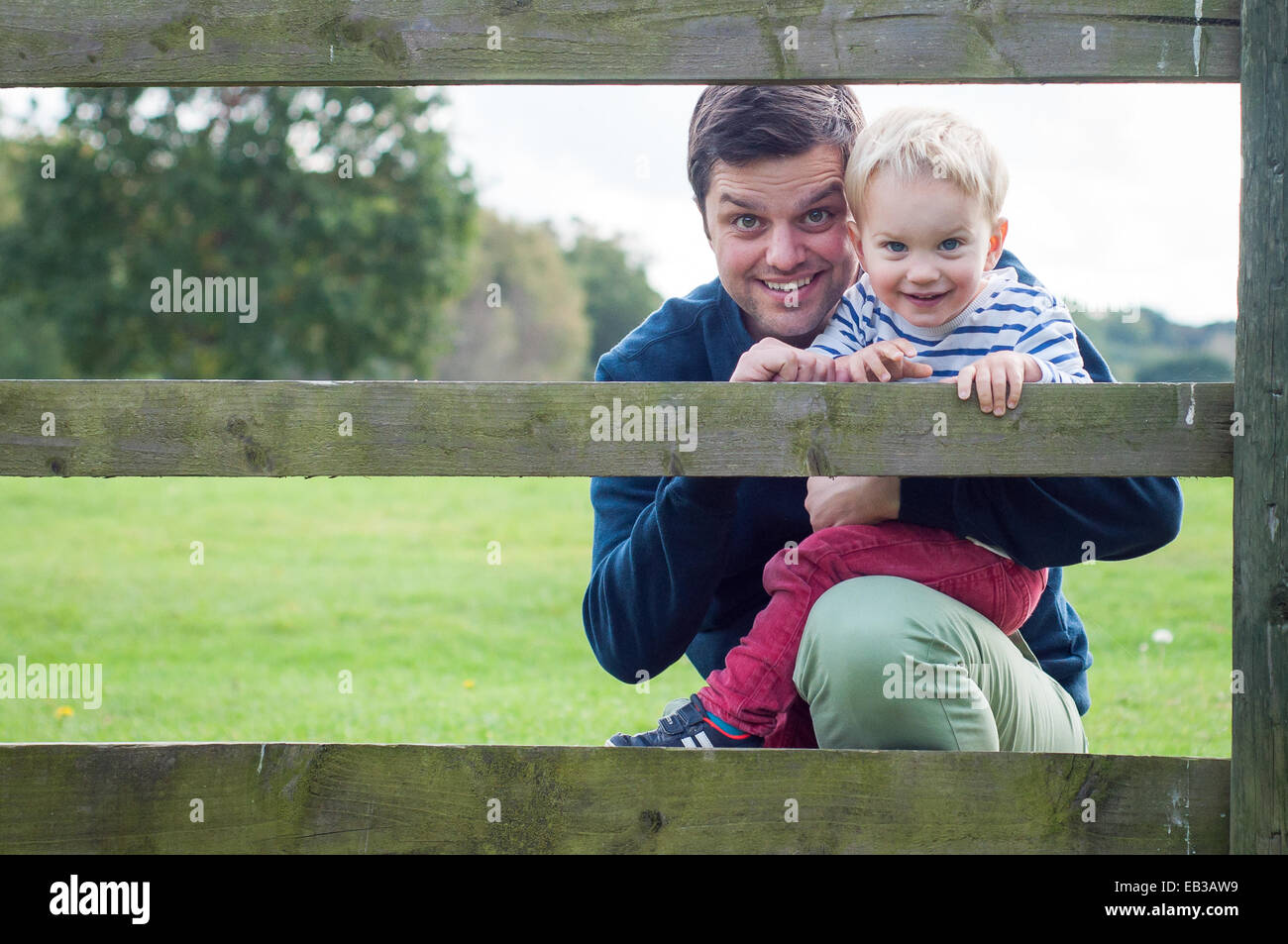 Father and son looking through a fence, England, UK Stock Photo - Alamy