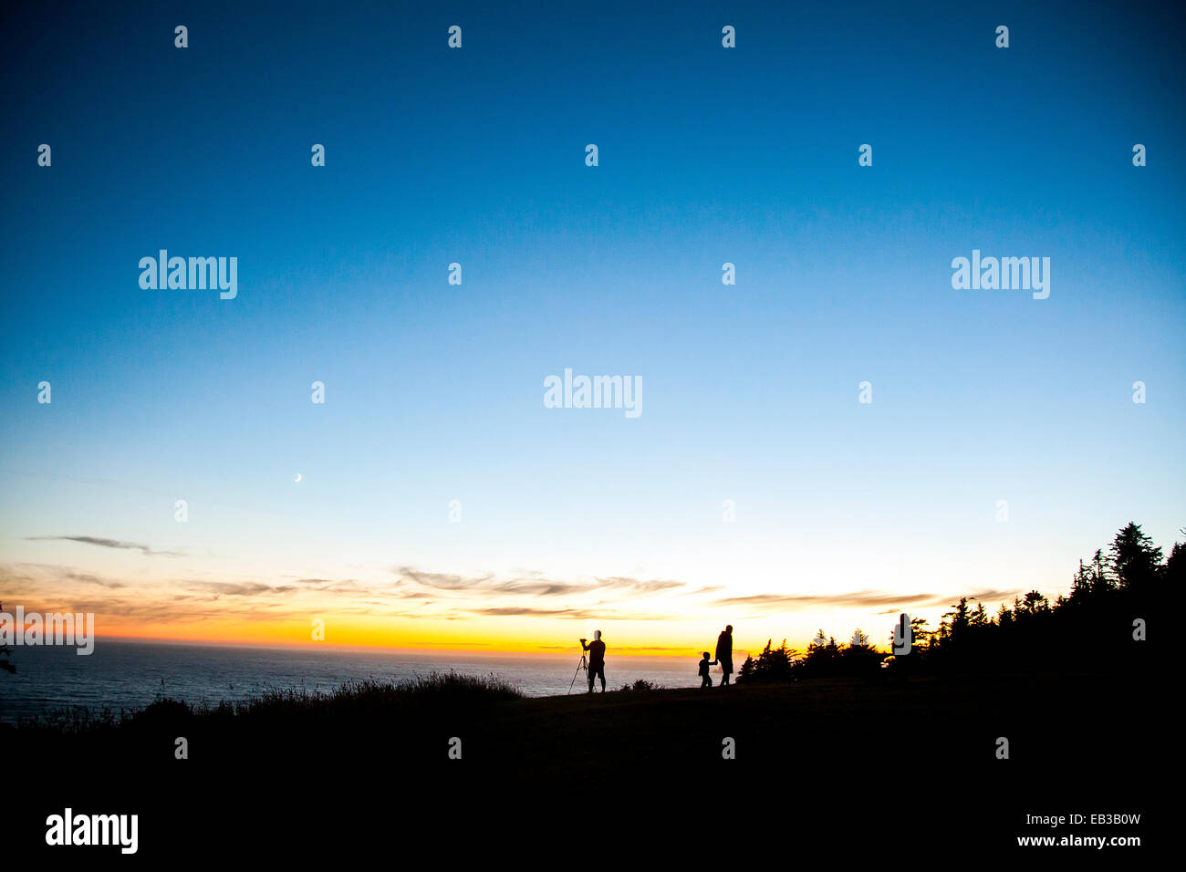 Silhouette of family on rural hillside at sunset Stock Photo - Alamy