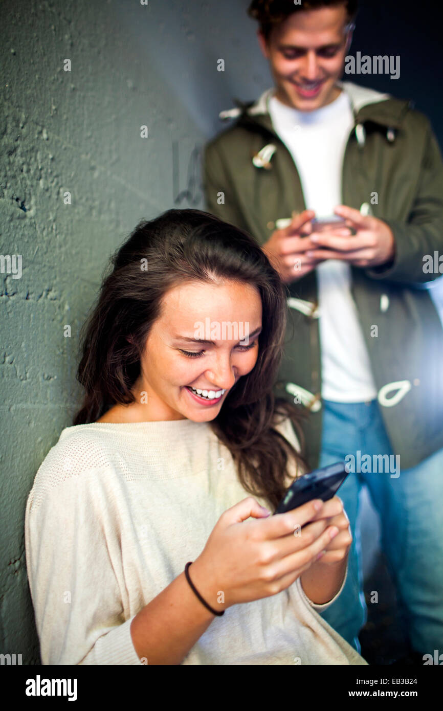 Caucasian couple using cell phones together in tunnel Stock Photo - Alamy