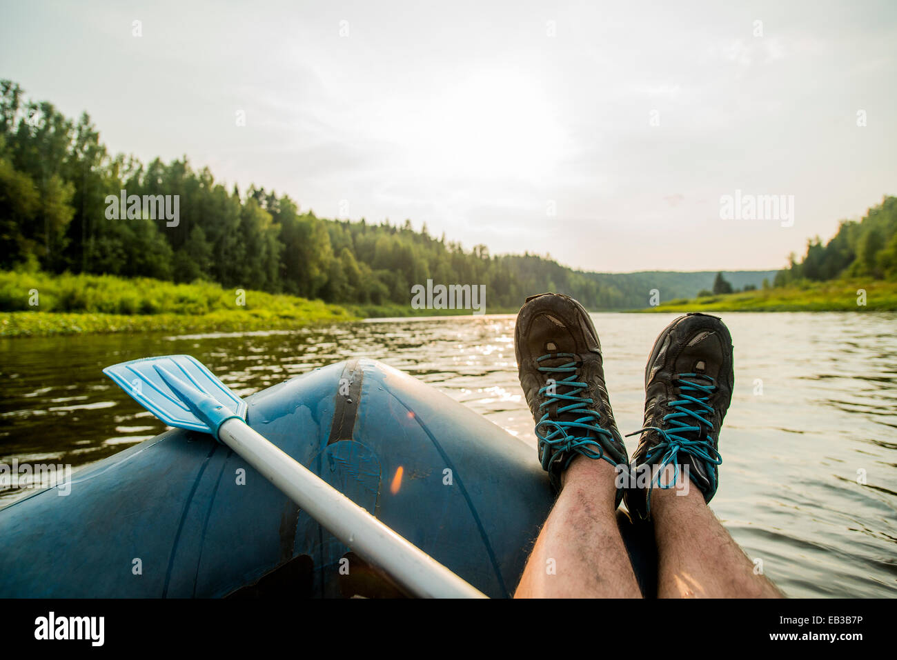 Man resting feet on boat in lake Stock Photo - Alamy