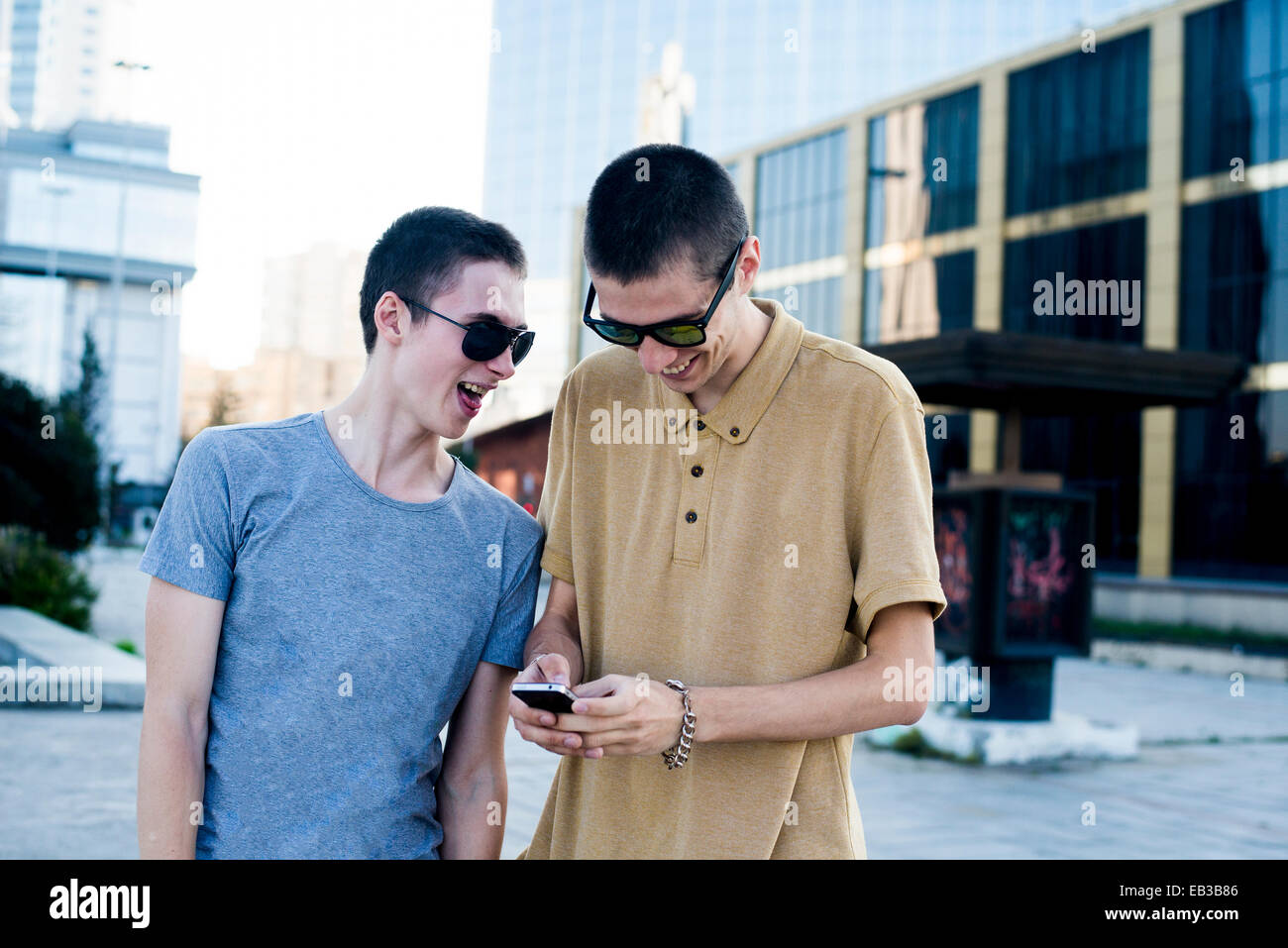Caucasian men using cell phone in city Stock Photo - Alamy