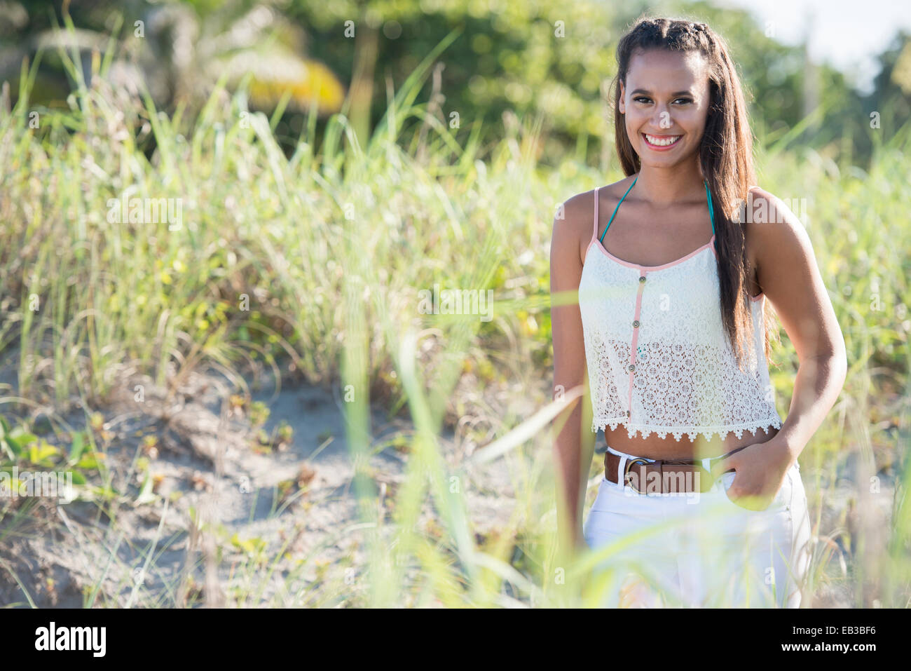 Mixed race woman smiling in tall grass Stock Photo - Alamy