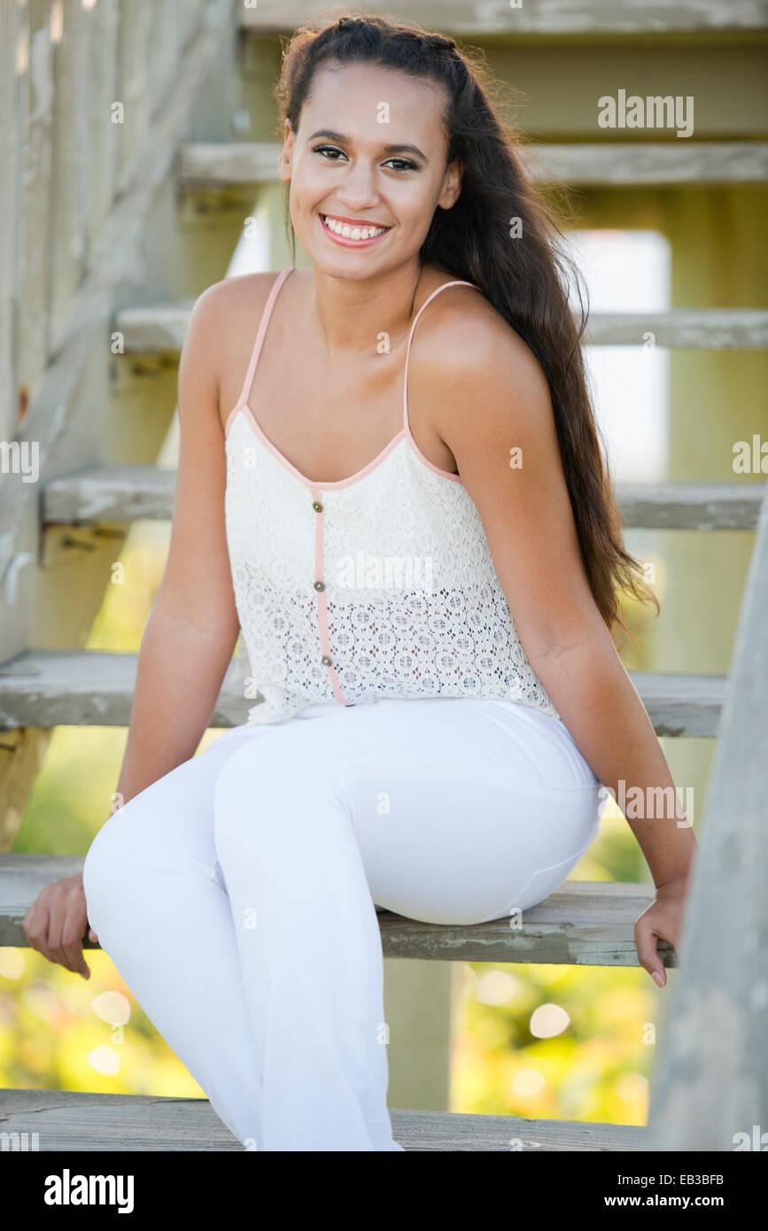 Mixed race woman sitting on wooden steps Stock Photo - Alamy