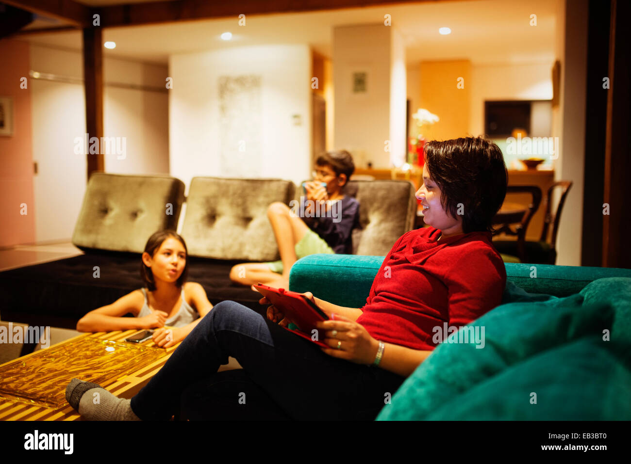 Family relaxing together in living room Stock Photo - Alamy