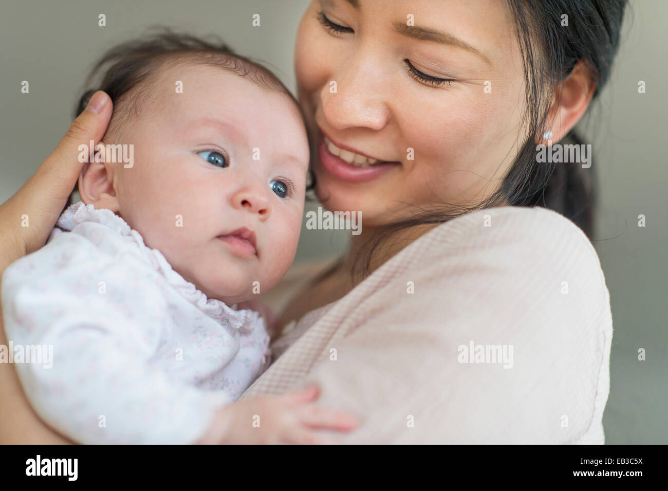 Asian mother holding baby Stock Photo - Alamy