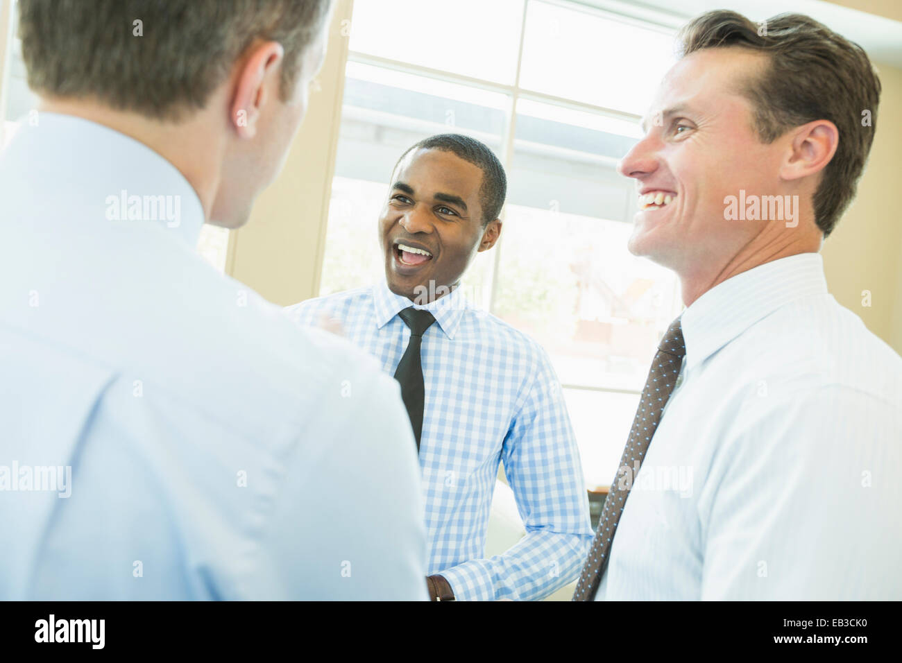 Smiling businessmen talking in office Stock Photo - Alamy