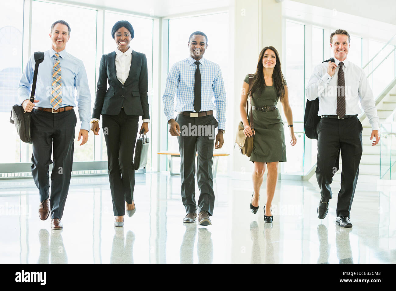 Business people walking in office lobby Stock Photo - Alamy