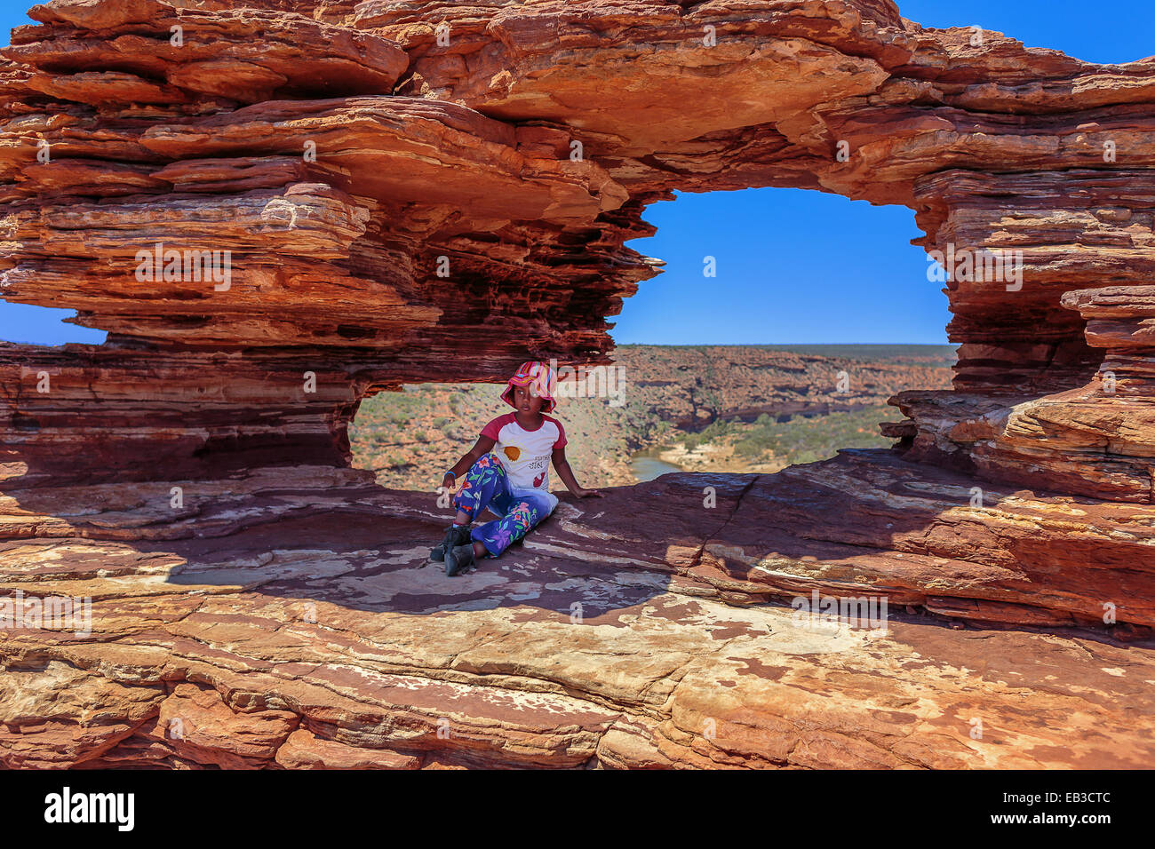 Girl sitting by natural arch, Kalbarri, Western Australia, Australia ...