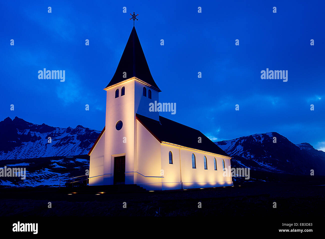 White church illuminated near snowy mountains at night Stock Photo - Alamy