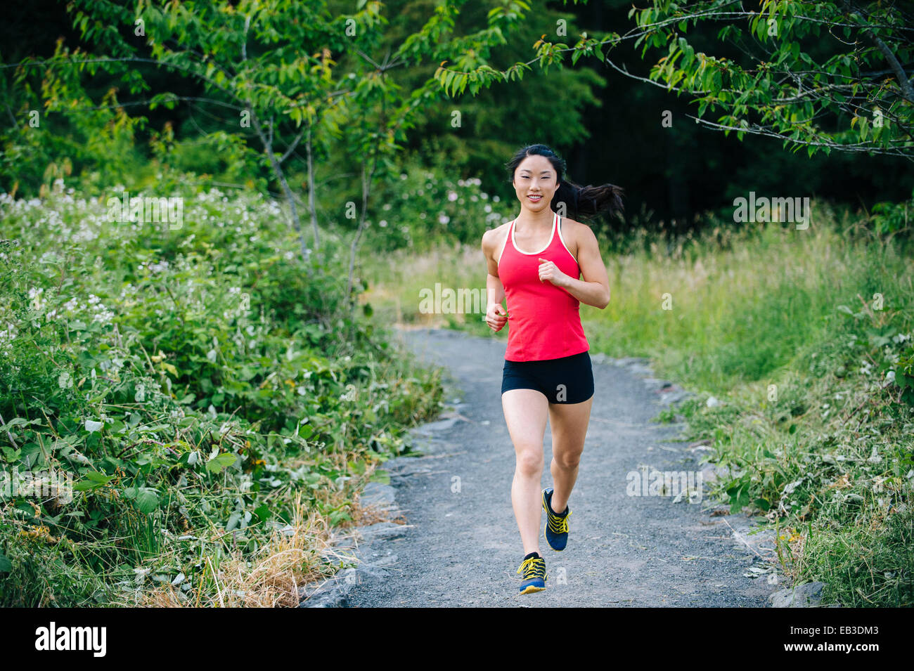 Korean woman running on remote path Stock Photo - Alamy