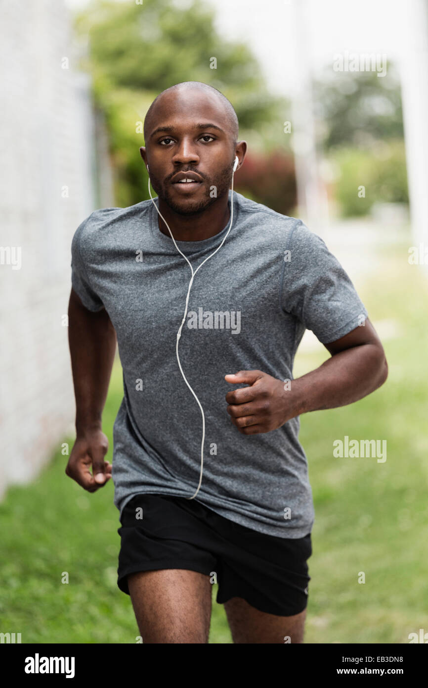 Black man running in urban grass Stock Photo - Alamy