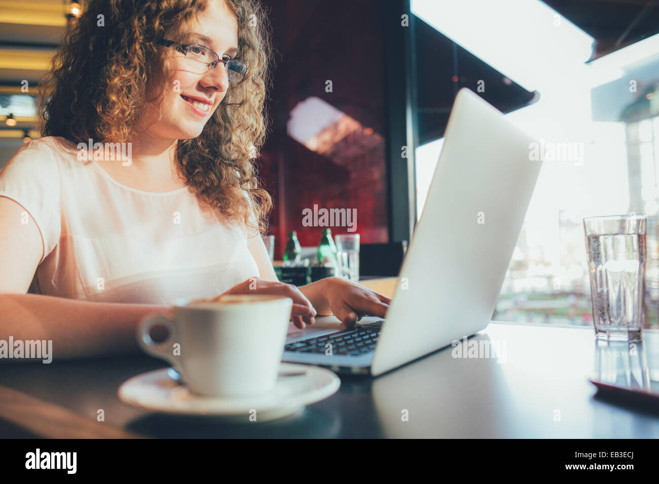 Woman using laptop computer in cafe Stock Photo - Alamy
