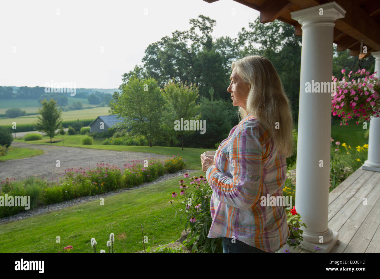 Older Caucasian woman overlooking rural scene from porch Stock Photo ...