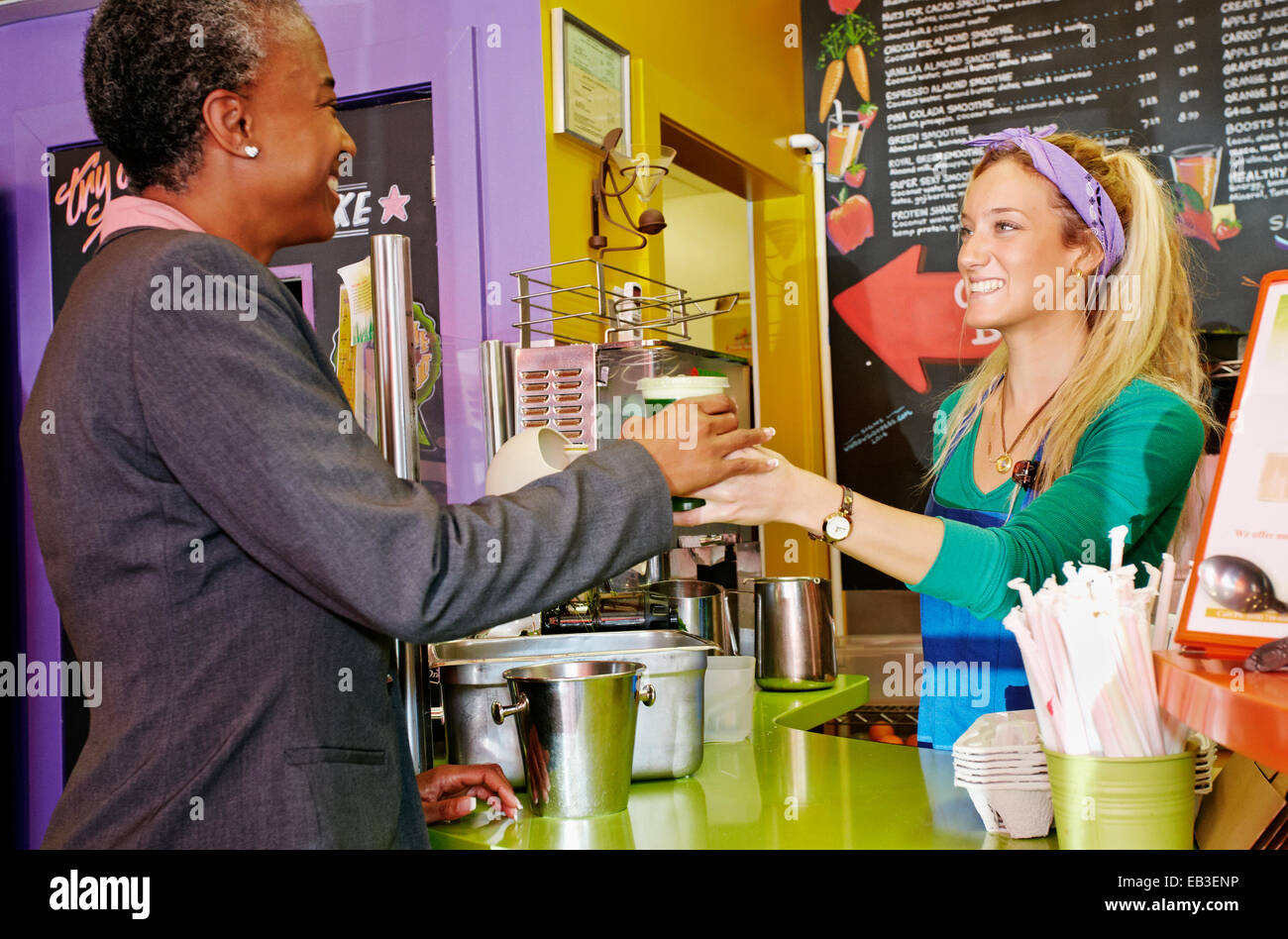 Woman serving customer smoothie in cafe Stock Photo - Alamy