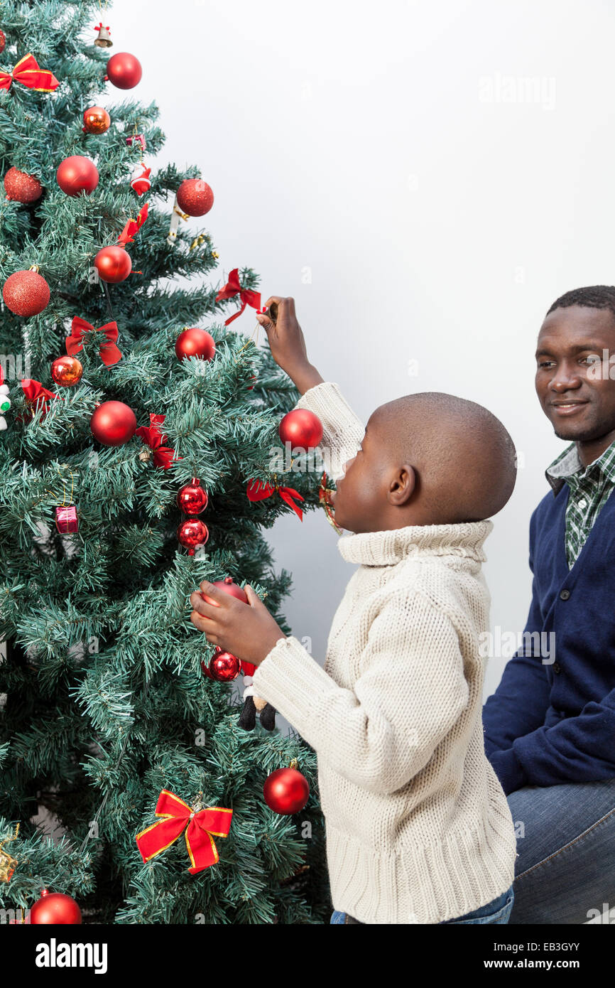 Boy decorating the christmas tree with his father Stock Photo - Alamy