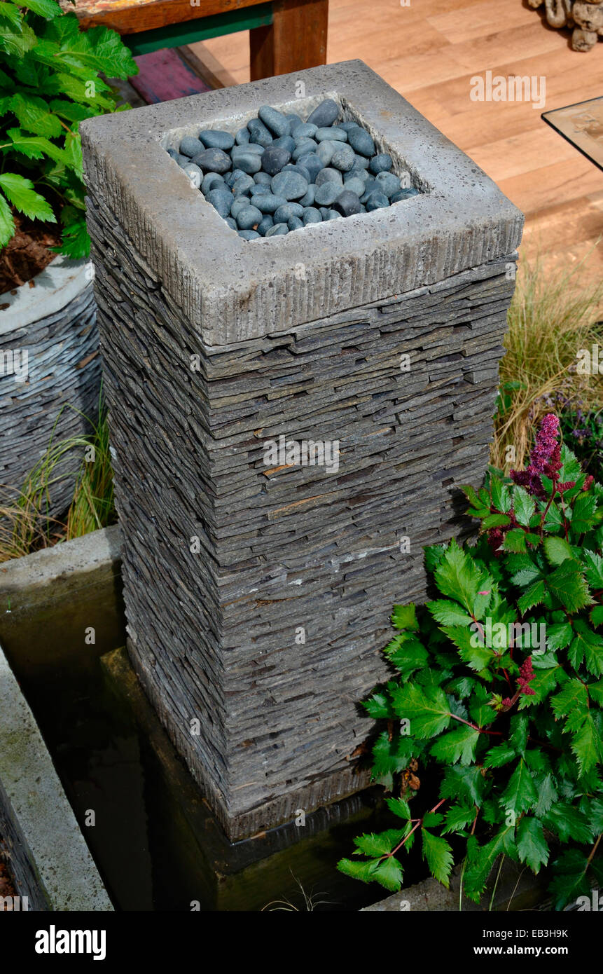 Garden detail of a craft made slate container with flowering plants ...