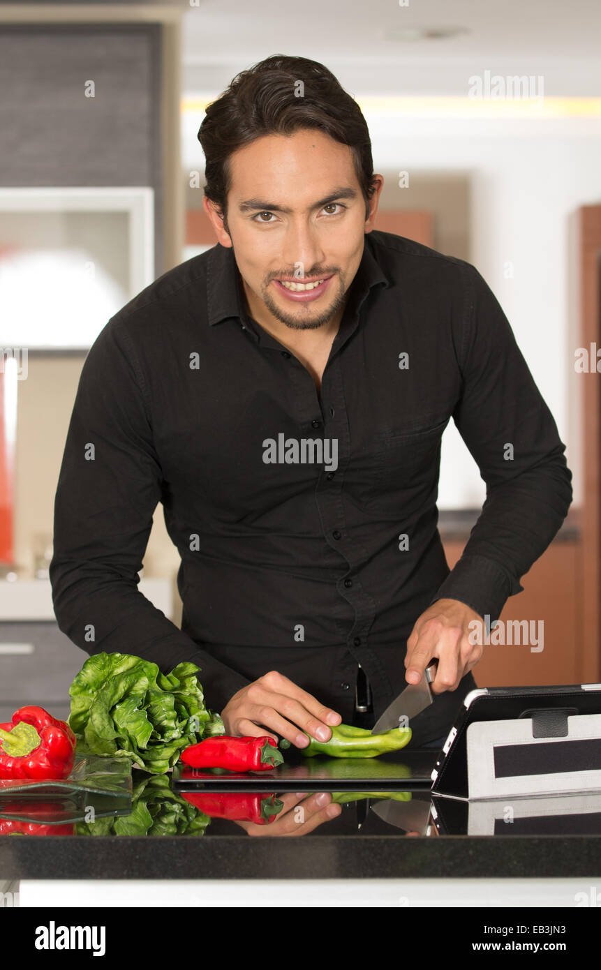 handsome young modern man cooking healthy recipe and using tablet Stock ...