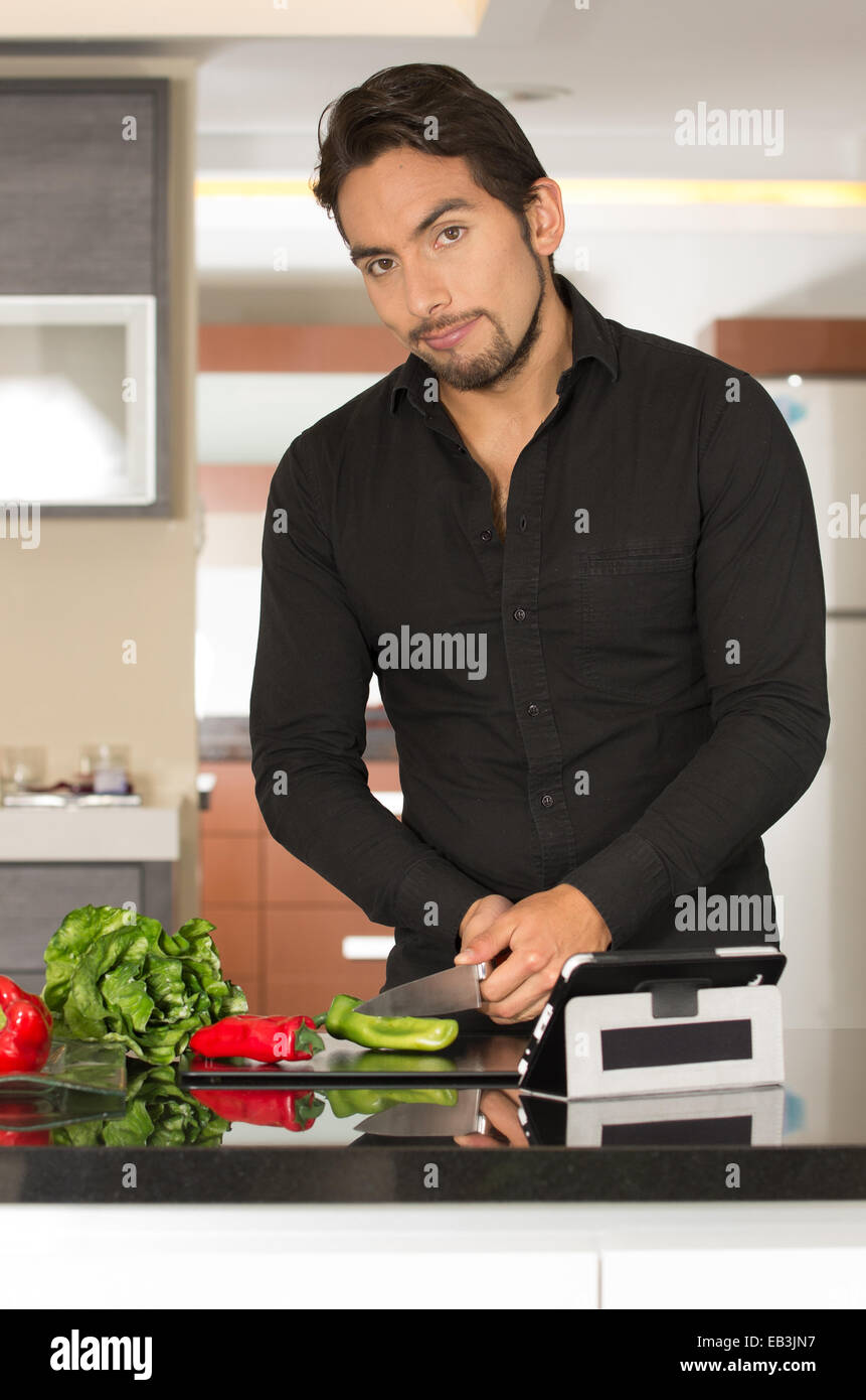 handsome young modern man cooking healthy recipe and using tablet Stock ...