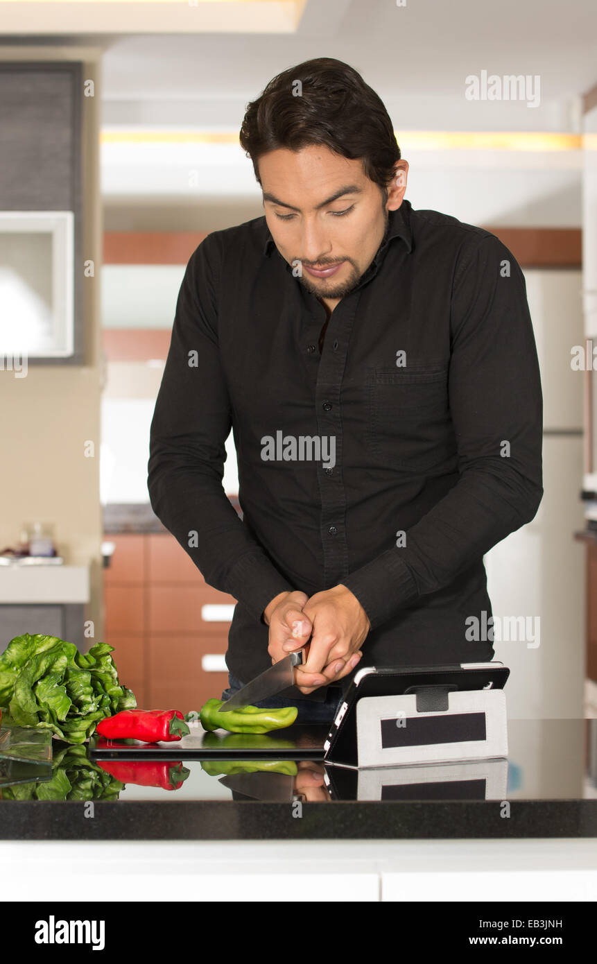 handsome young modern man cooking healthy recipe and using tablet Stock ...