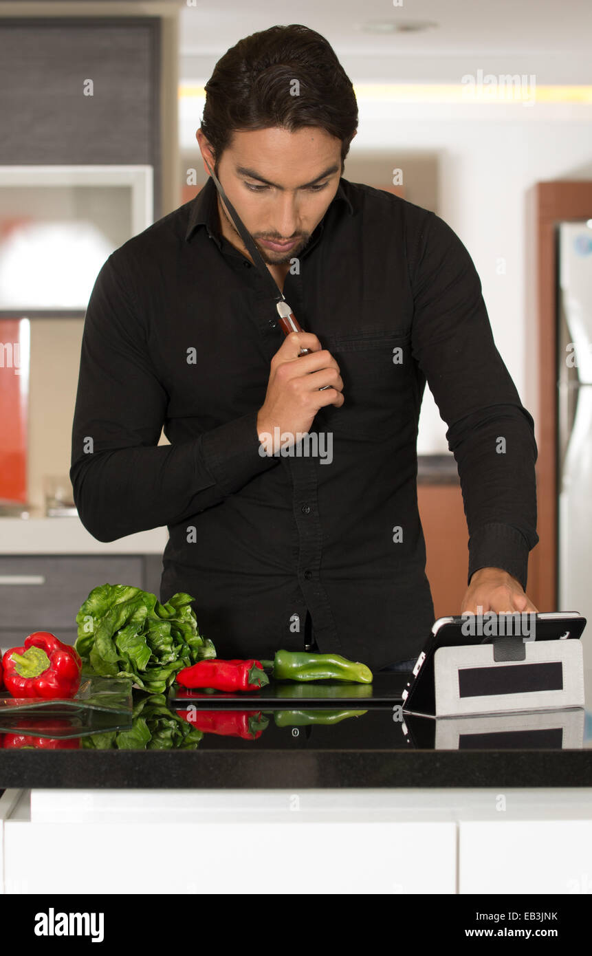 handsome young modern man cooking healthy recipe and using tablet Stock ...