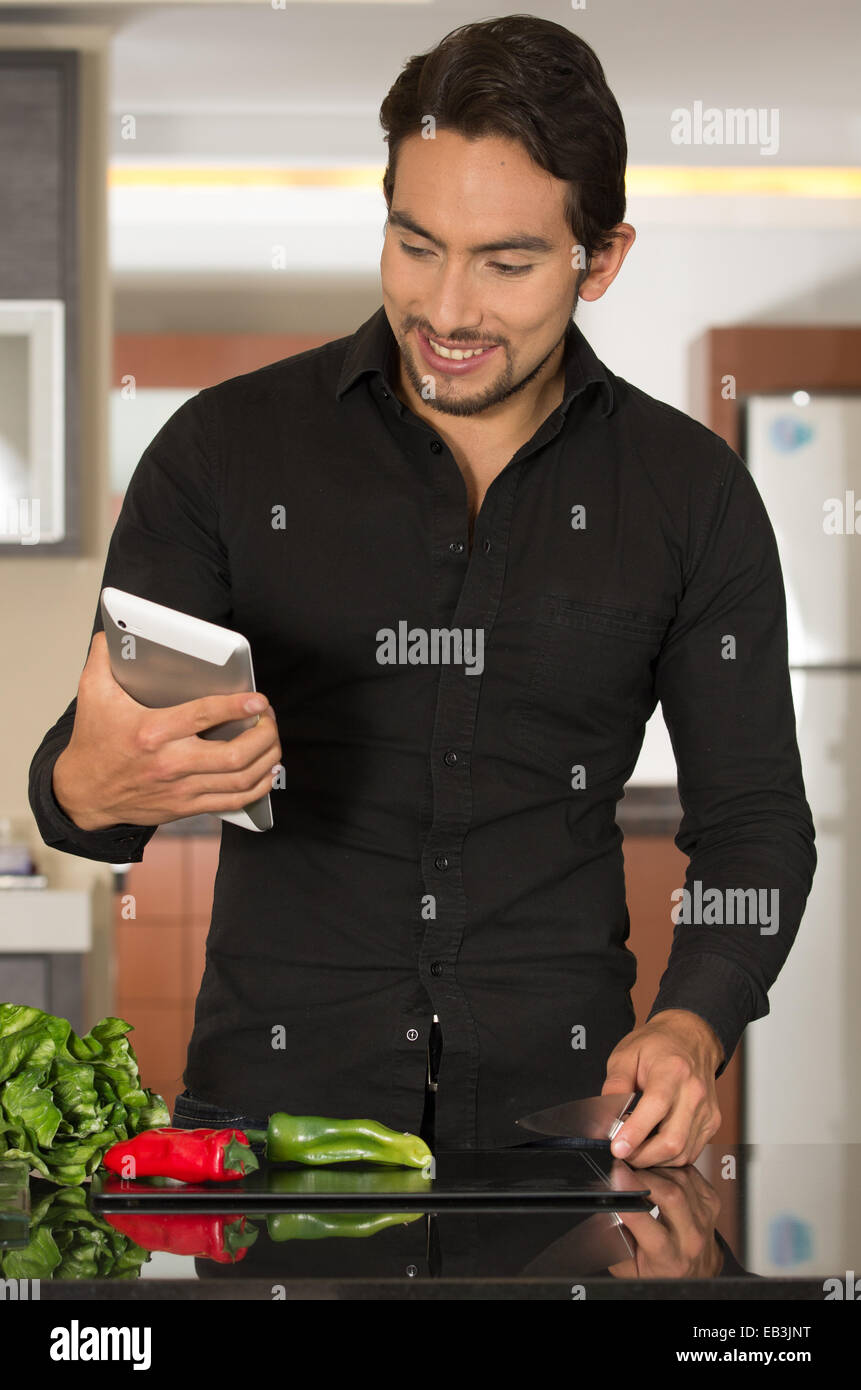 handsome young modern man cooking healthy recipe and using tablet Stock ...