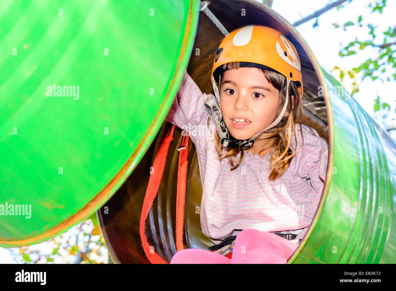 Little girl is going through the barrels in adventure park Stock Photo ...