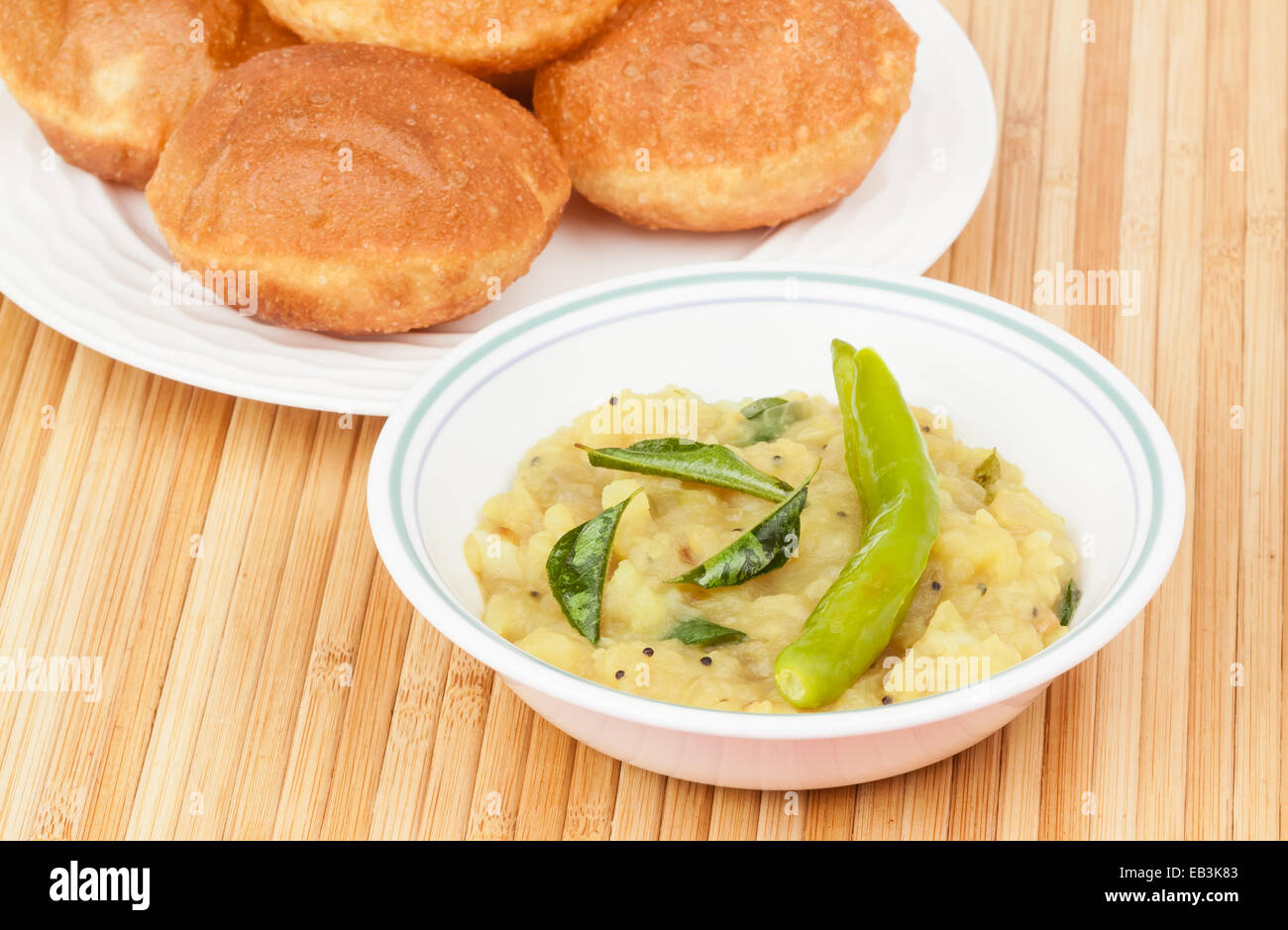 Delicious deep fried poori (puri) served with spicy potato onion curry ...
