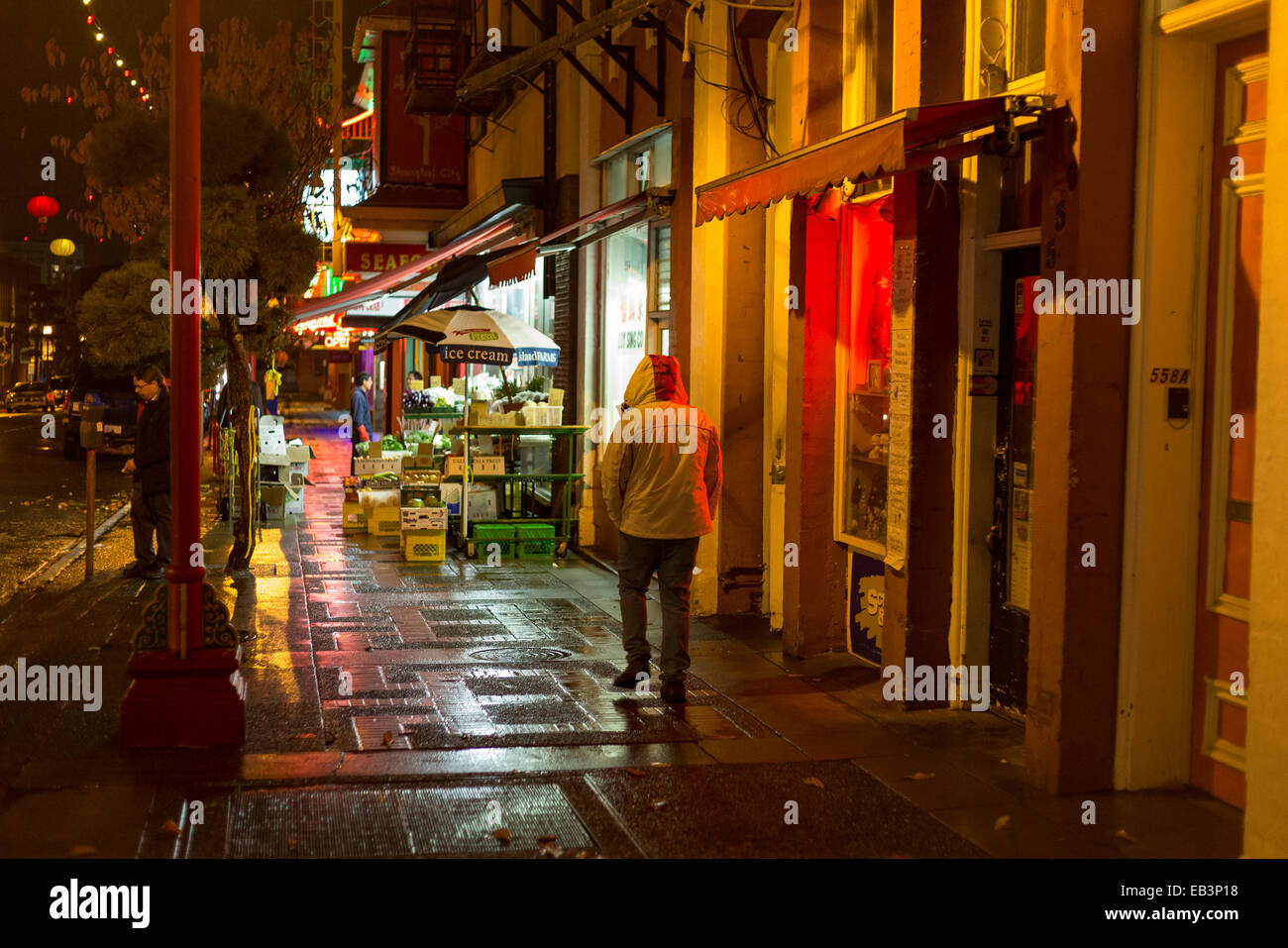 Man with hood on jacket up walking in Chinatown on rainy night-Victoria ...