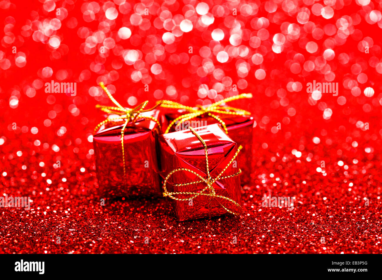 Decorated red holiday gifts on glitter background Stock Photo - Alamy