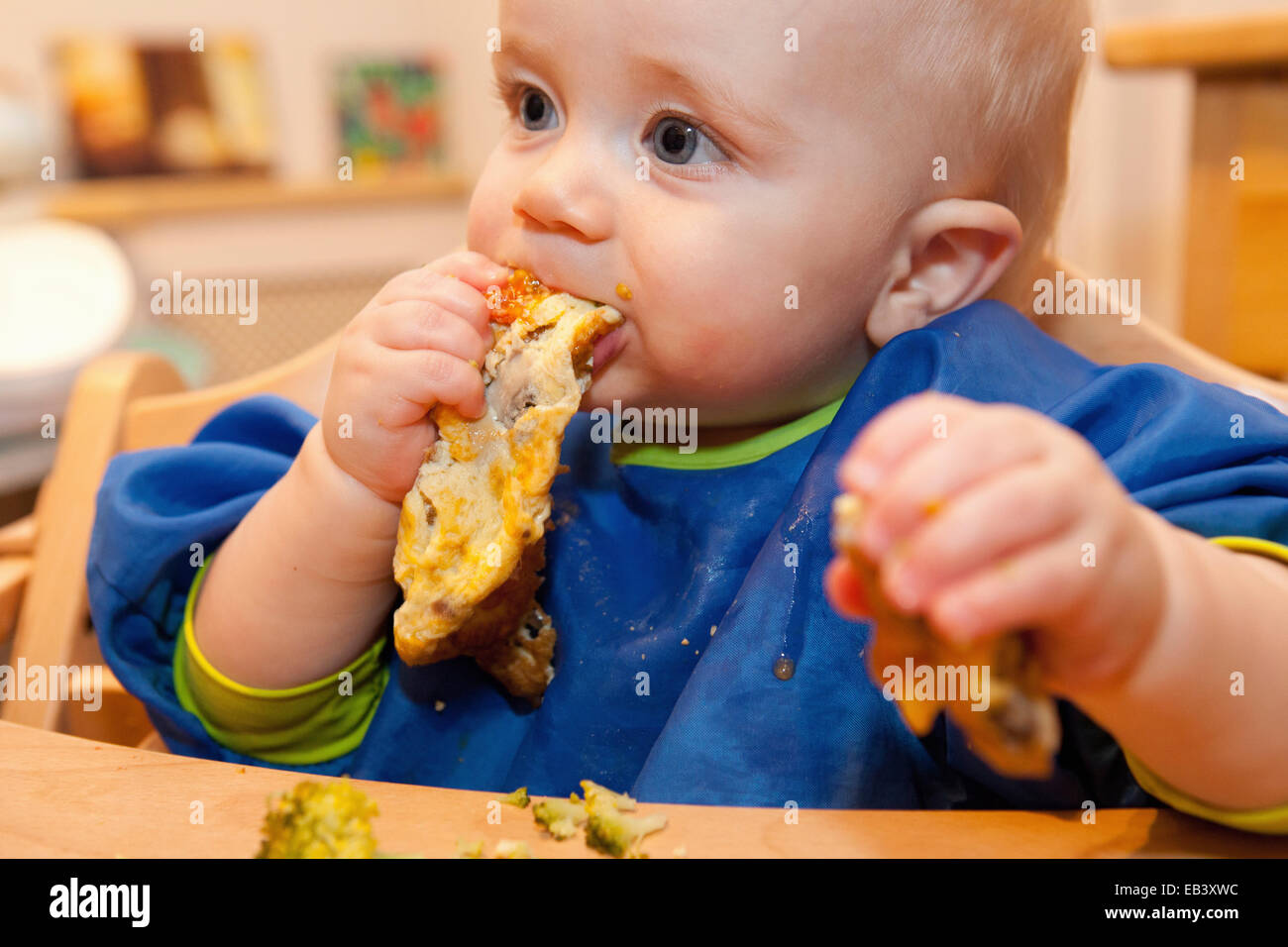 Baby feeding himself Stock Photo - Alamy