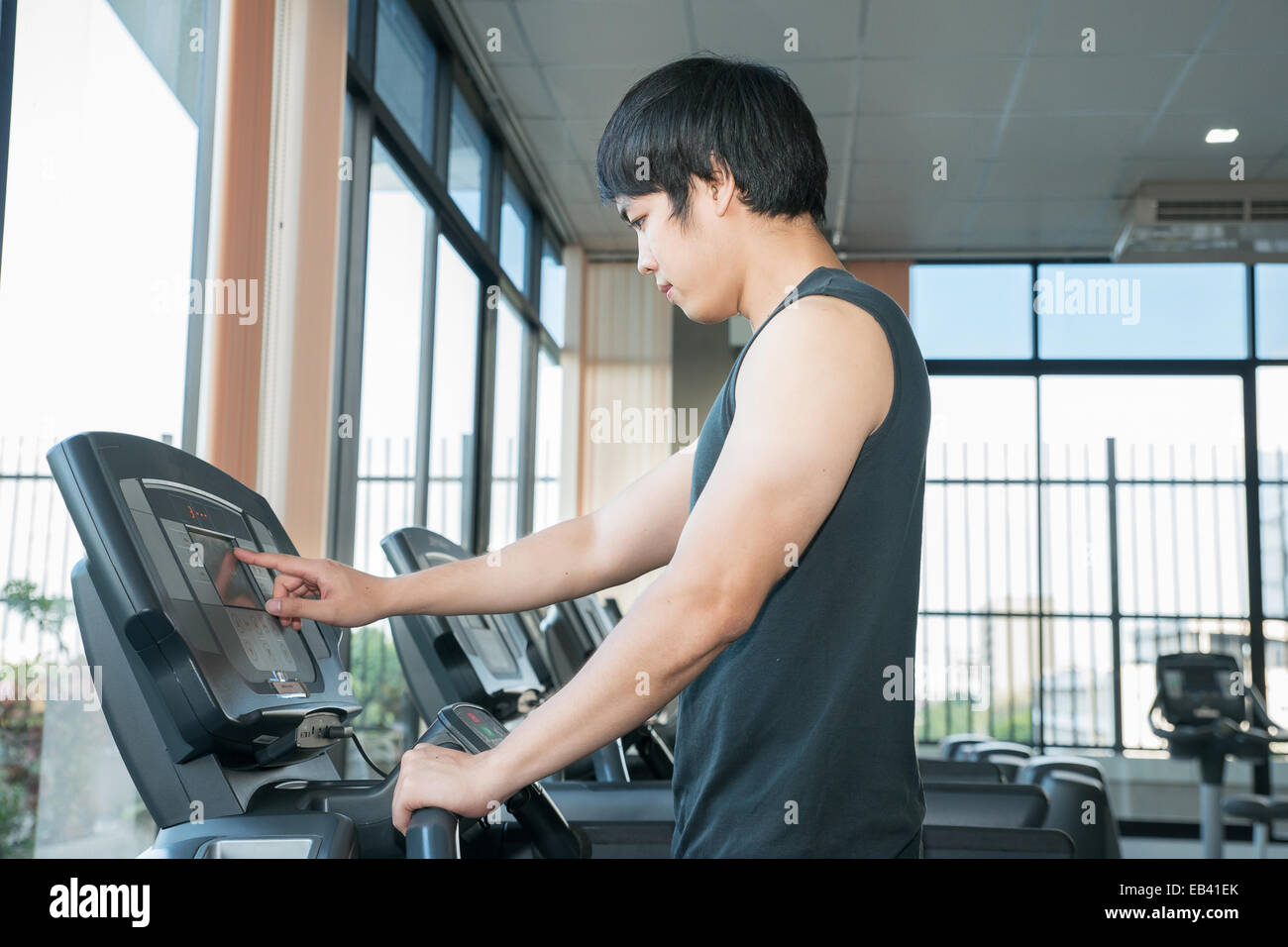 Man at the gym doing set up treadmill for fitness Stock Photo - Alamy