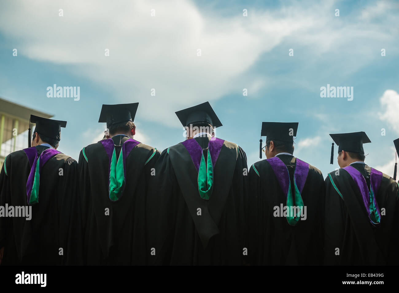 Back of graduates with blue sky Stock Photo - Alamy
