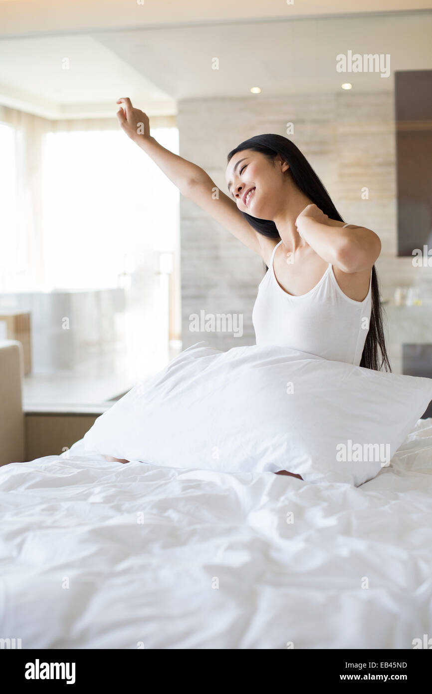 Young woman stretching in bed Stock Photo - Alamy
