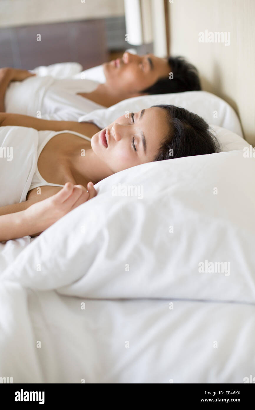 Young couple sleeping on bed Stock Photo - Alamy