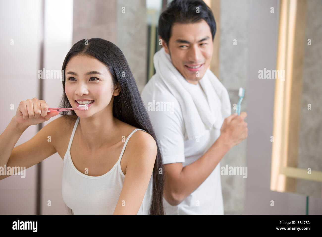 Young couple brushing teeth together Stock Photo - Alamy