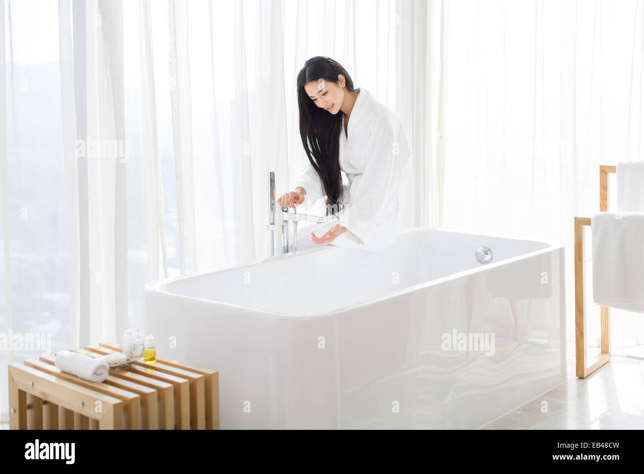 Young woman filling bathtub Stock Photo - Alamy