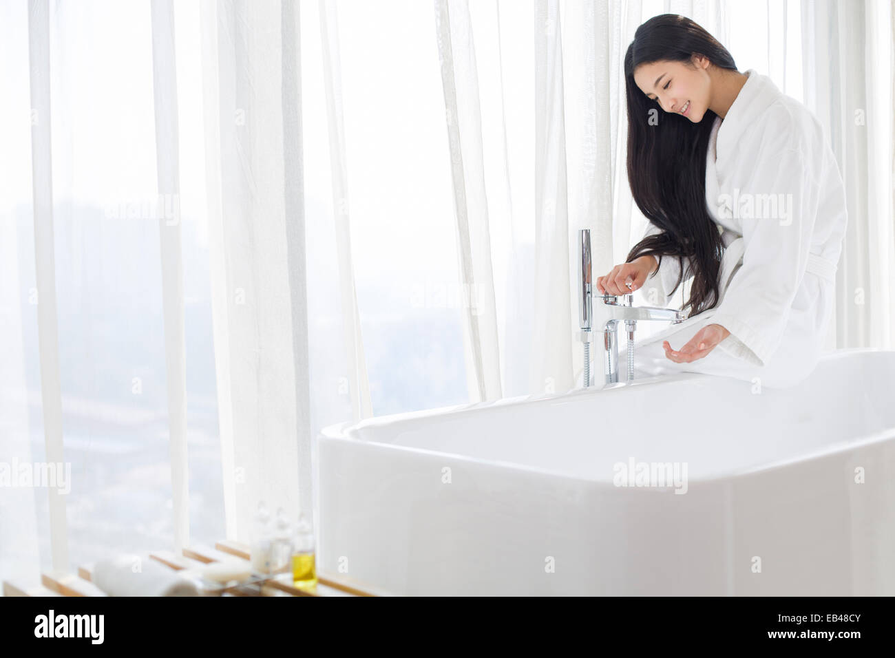 Young woman filling bathtub Stock Photo - Alamy